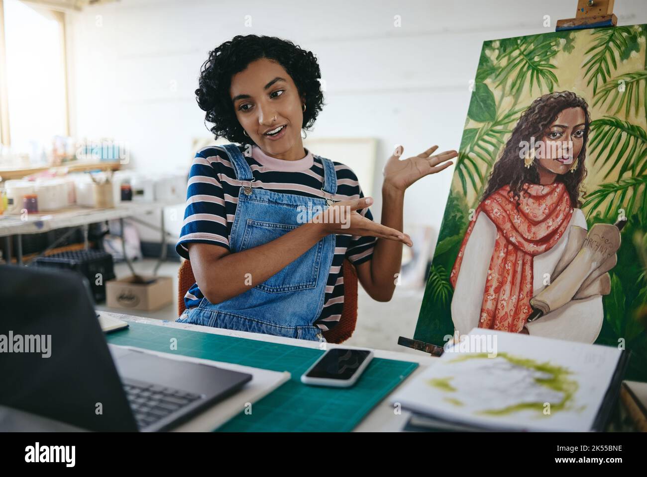 Painting, video call and laptop with woman and art in workshop studio ...