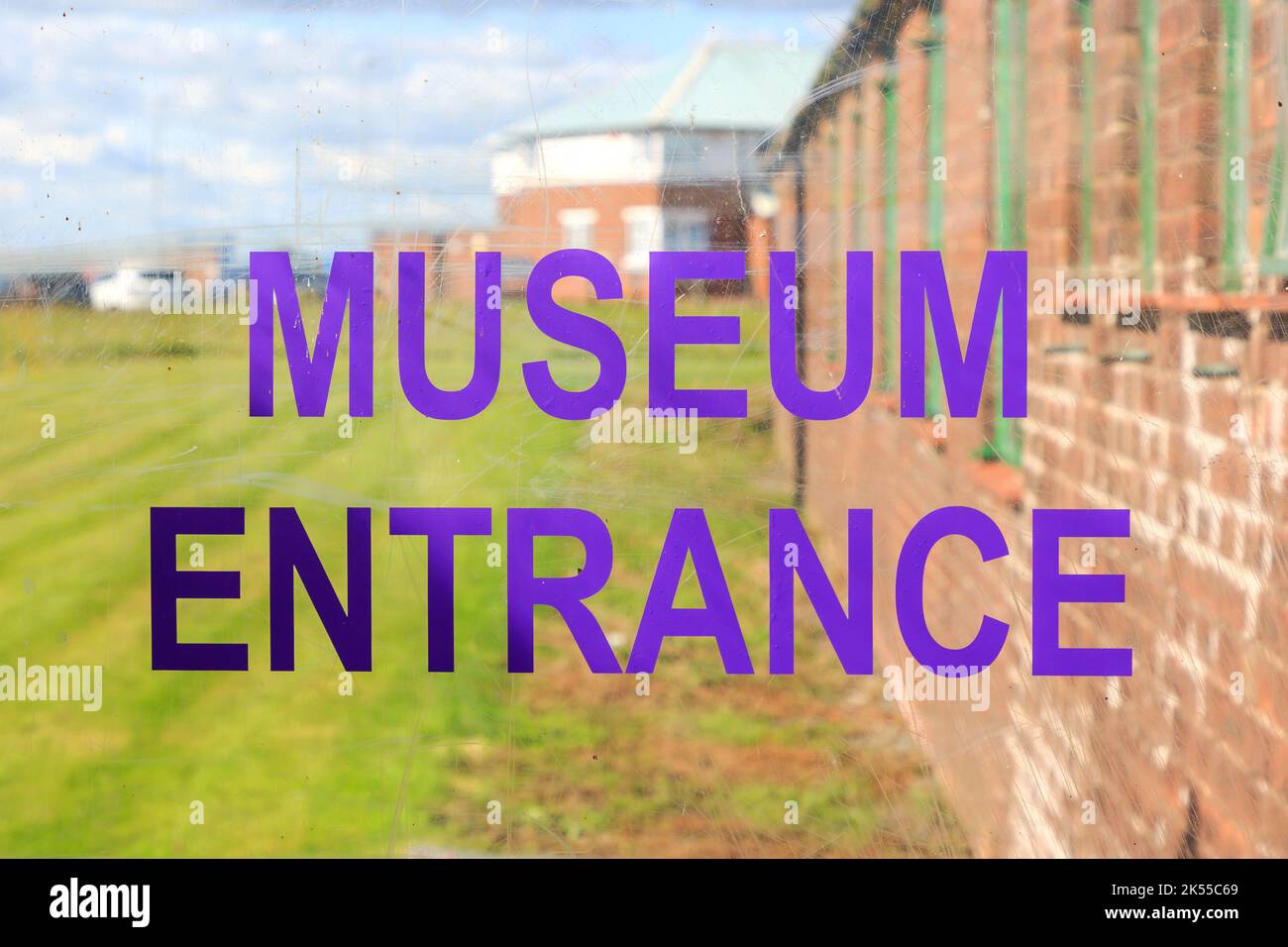 Museum entrance purple text lettering fixed to a clear glass panel ...