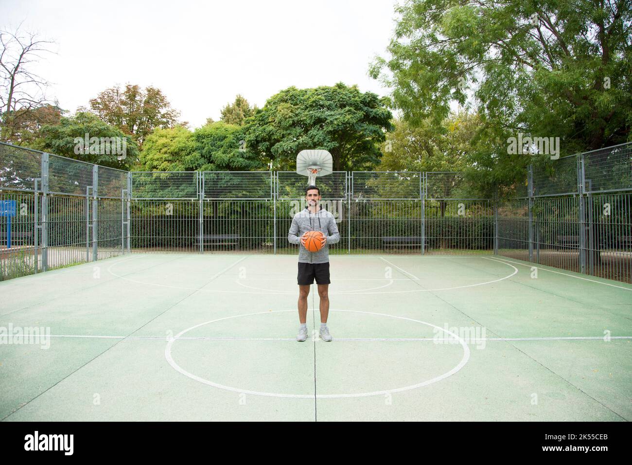 Portrait with copy space of a basketball player in an outdoor court ...