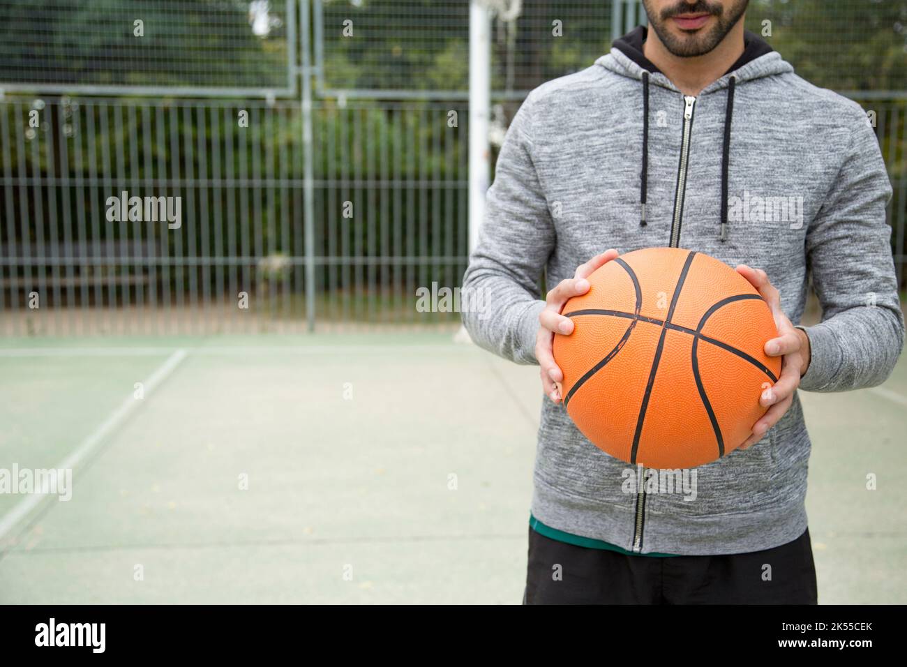 Cropped photo of a sportive man holding a basketball ball Stock Photo ...