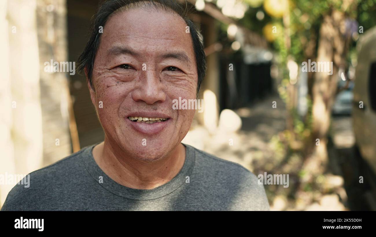 Closeup face of a Japanese man standing in street looking at camera ...