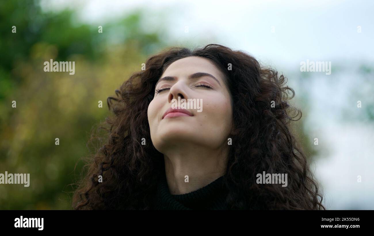 Hopeful woman closing eyes in meditation. Female person standing ...