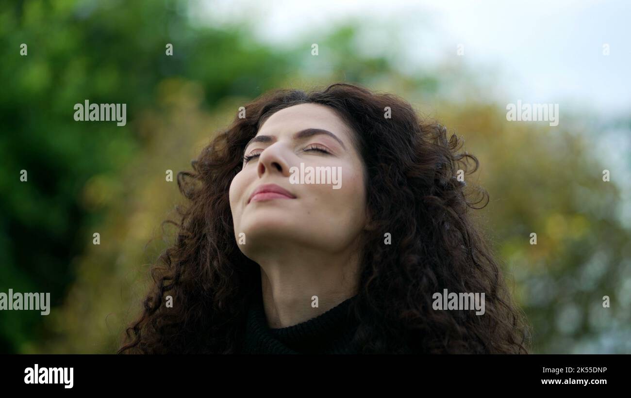 Hopeful woman closing eyes in meditation. Female person standing ...