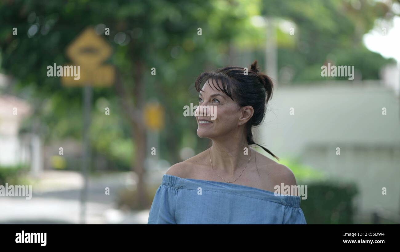 One contemplative middle age woman standing in street in mindfulness ...