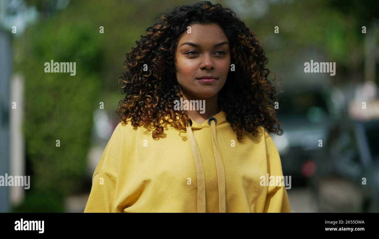 One confident African American young woman walking in city street ...