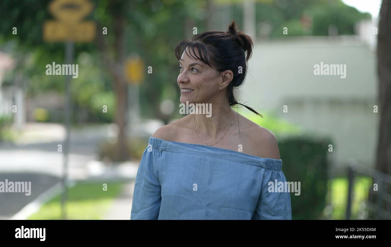 One contemplative middle age woman standing in street in mindfulness ...