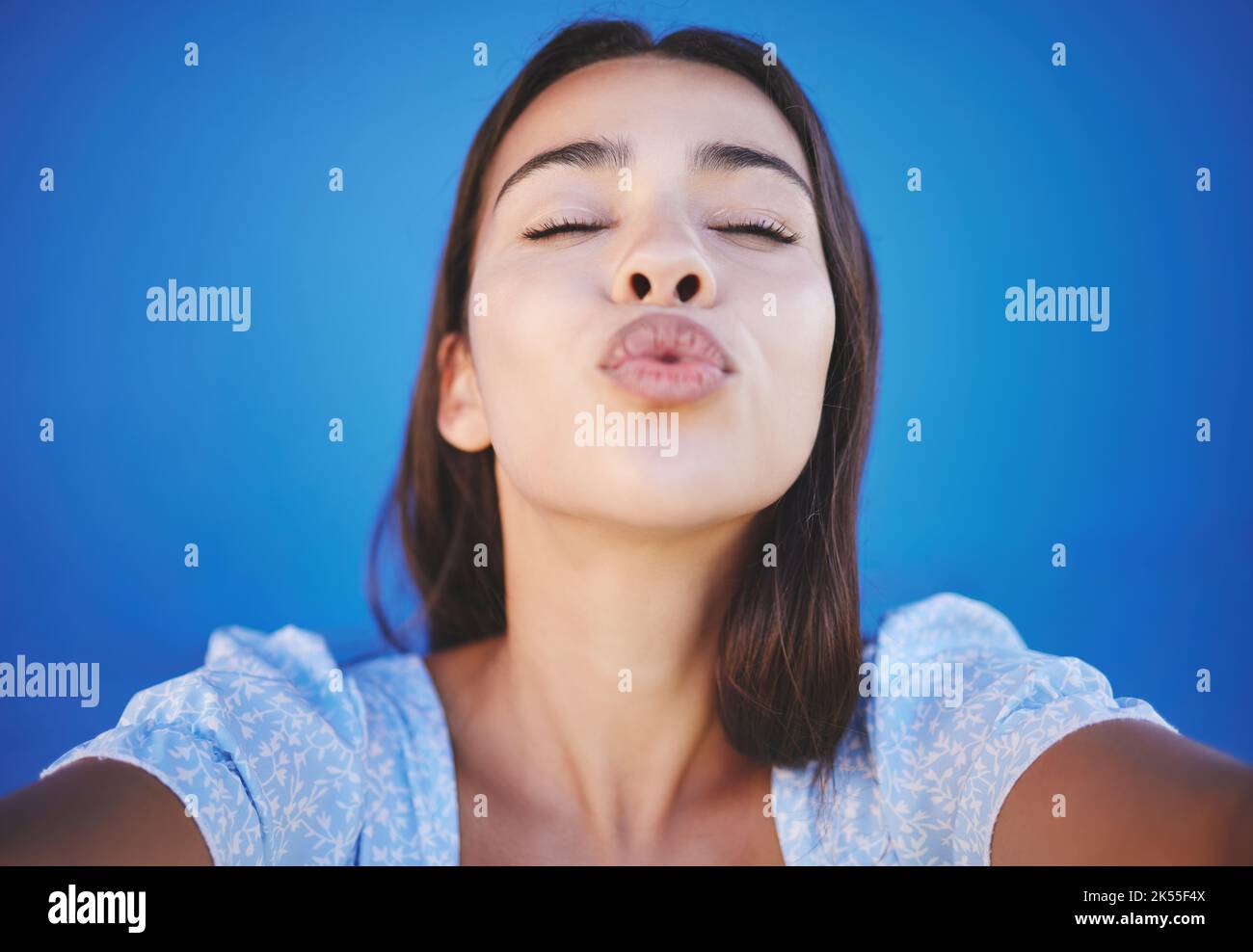 Woman face, blowing kiss and selfie portrait blue background for love ...
