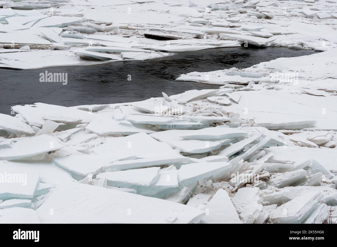 Ice jammed river. Large slabs of broken jagged ice clog the river. The ...