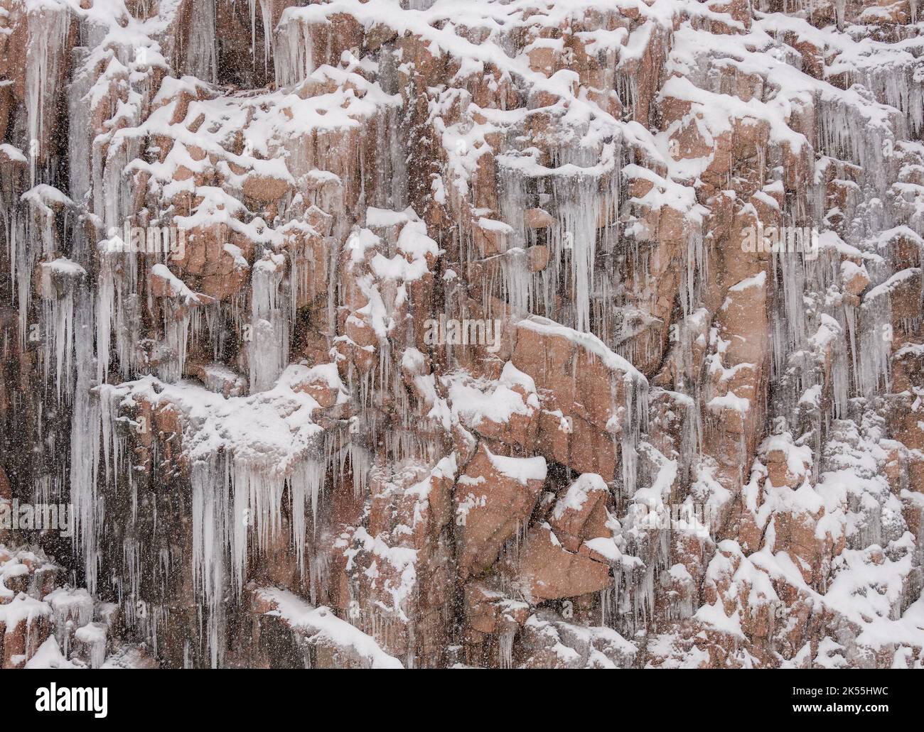 Icicles hanging from a snow covered granite cliff. Taken during a ...