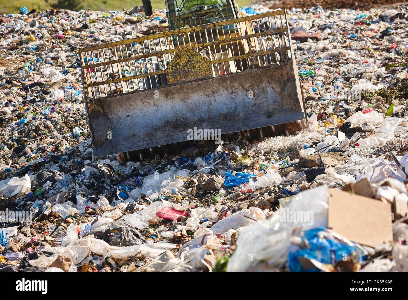 Heavy machinery shredding garbage in an open air landfill. Waste Stock ...