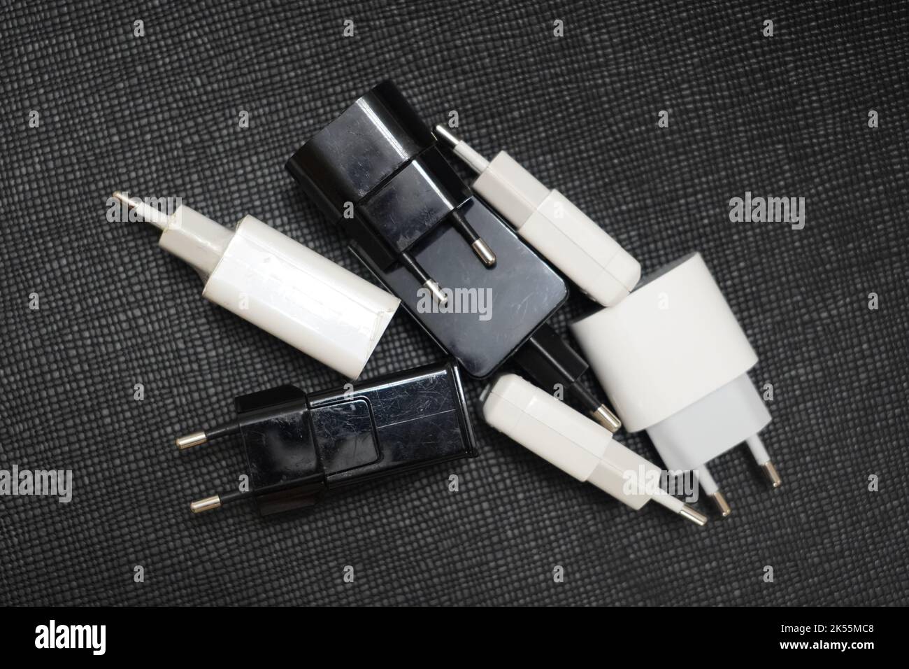 many phone charger adapters of different types on a black background ...