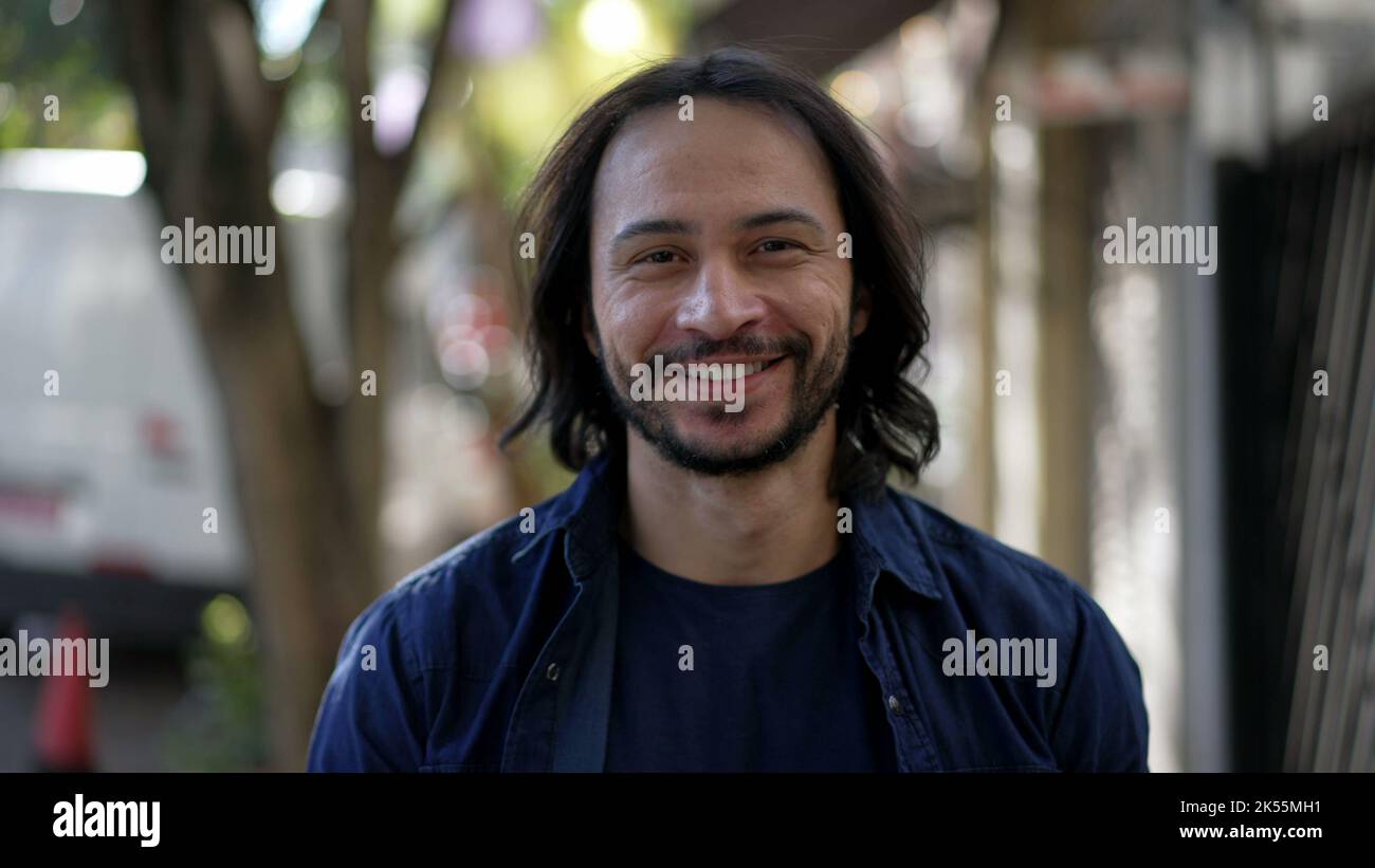 Portrait of a happy hispanic man walking forward in street. Smiling ...