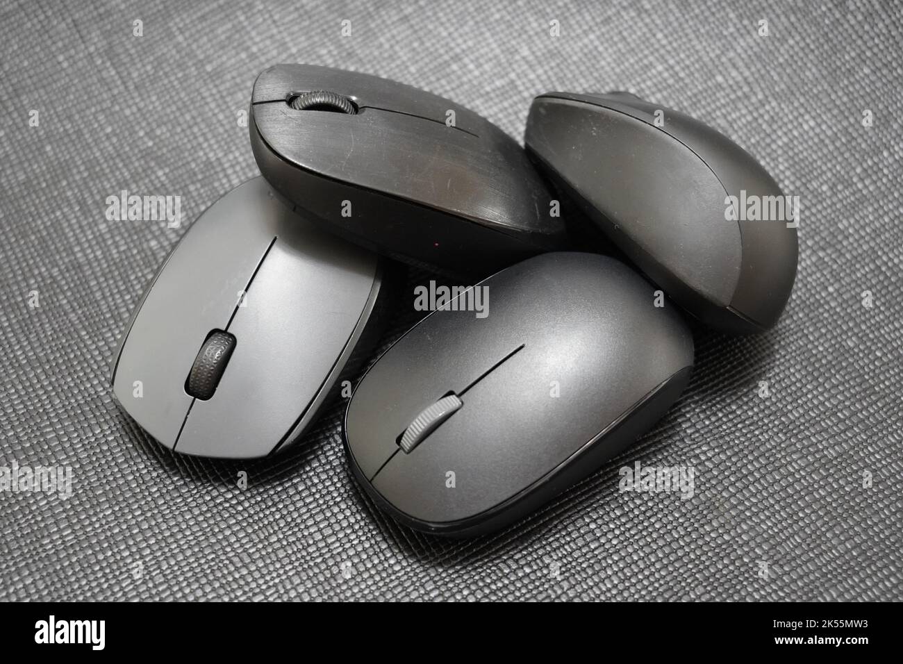 four different wireless mice on a black background Stock Photo - Alamy