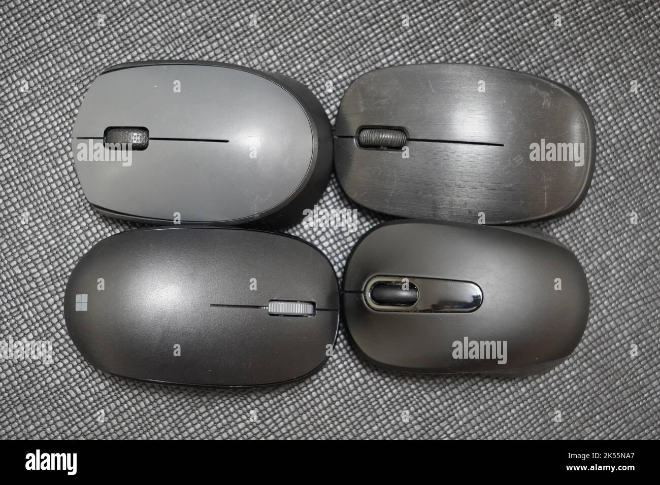 four different wireless mice on a black background Stock Photo - Alamy