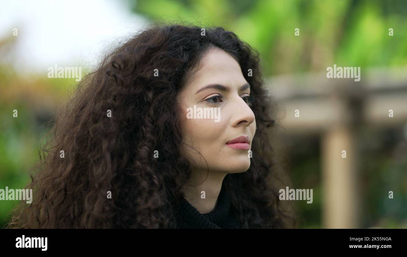 One woman standing outdoors in contemplation. Pensive thoughtful female ...