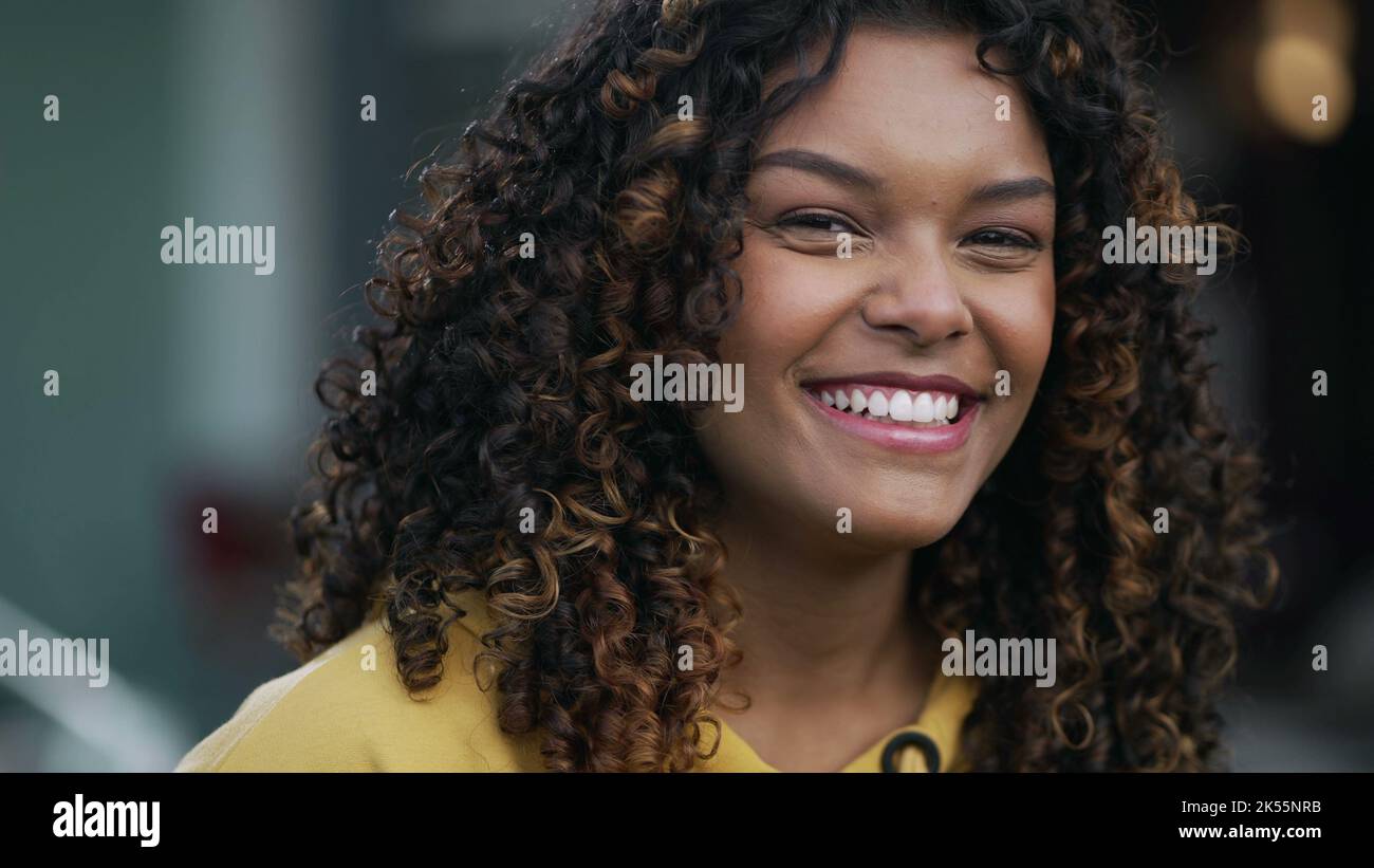 Portrait of a happy black hispanic young woman looking at camera. Young ...