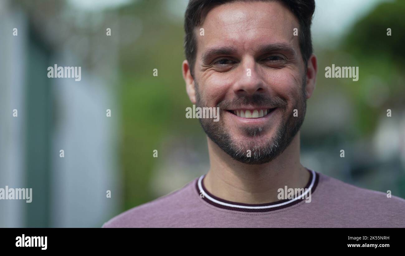 Portrait of a young handsome man in 30s walking toward camera smiling ...