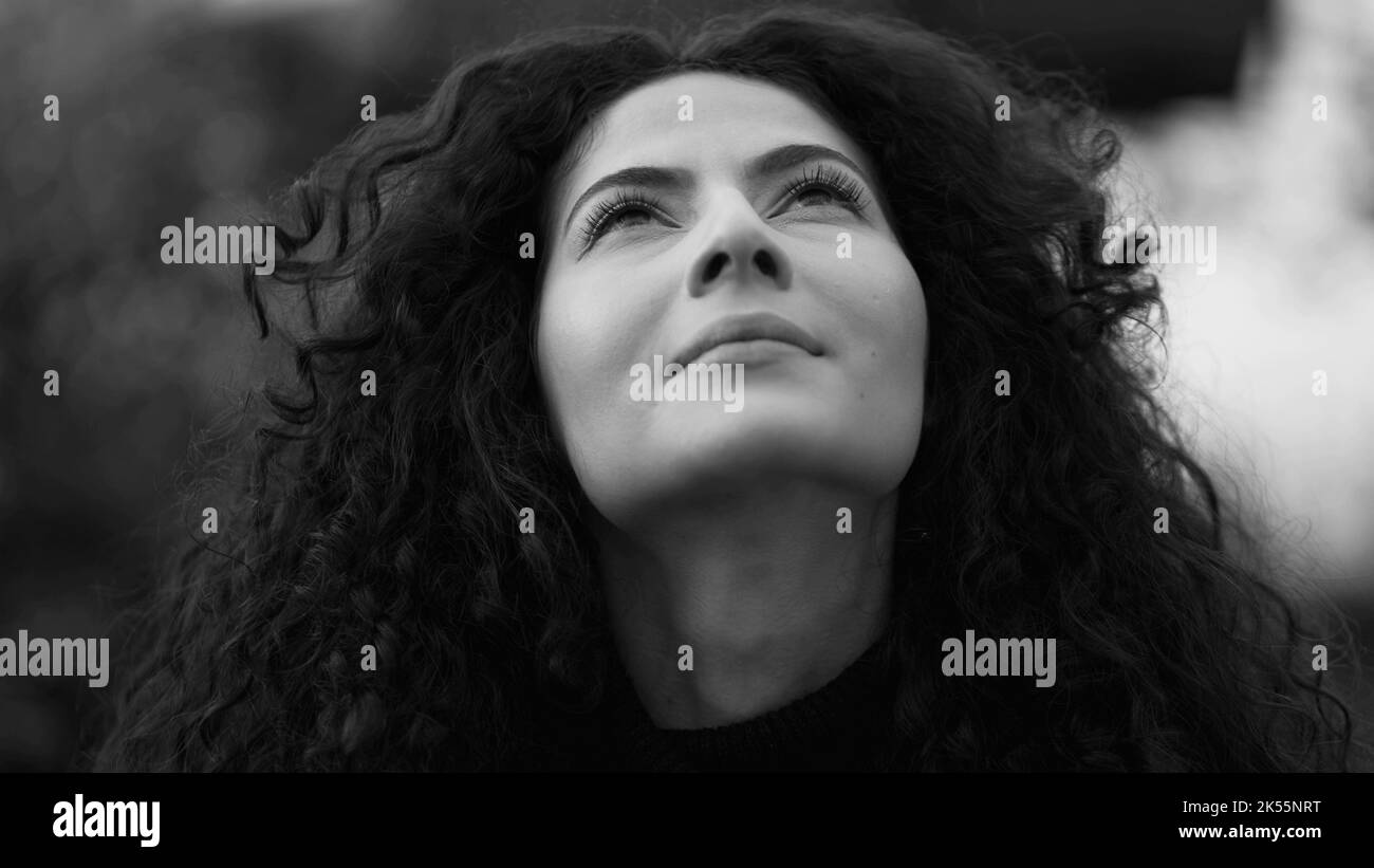 Woman standing outdoors in contemplation in monochromatic. Black and ...