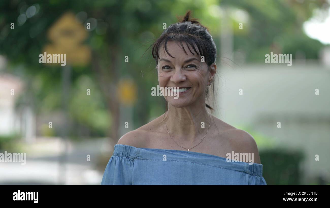 Portrait of a happy middle aged woman smiling at camera standing ...