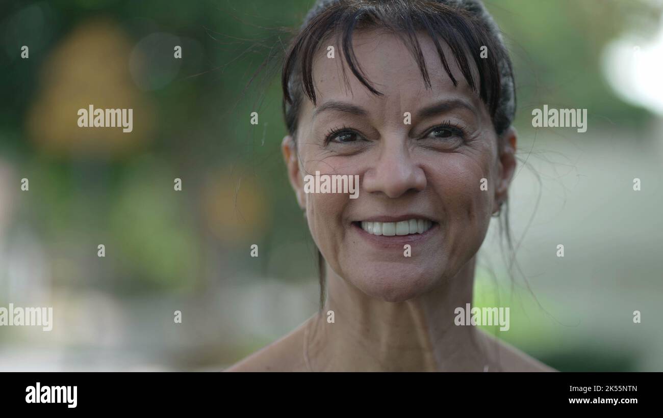 Portrait of a happy middle aged woman smiling at camera standing ...