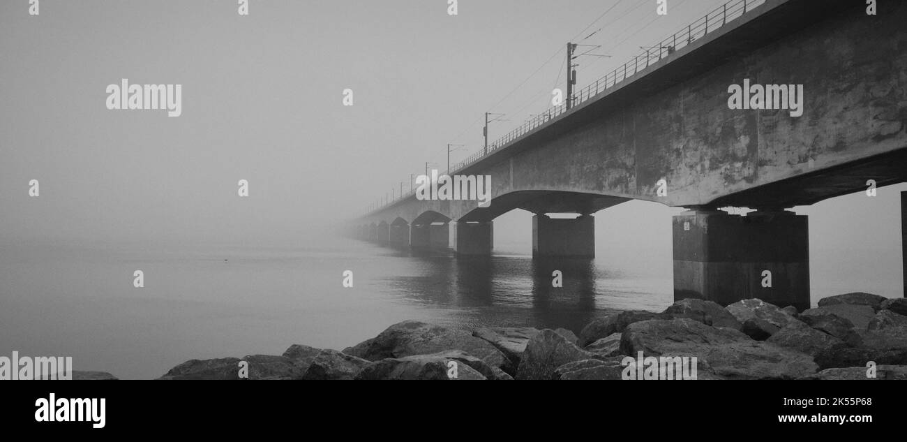 A beautiful panoramic shot of a bridge in foggy weather in Denmark ...