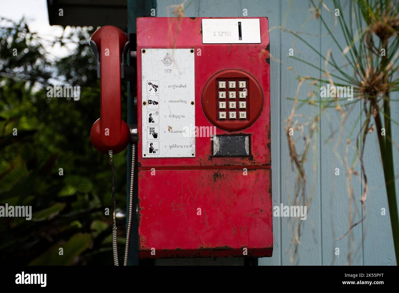 Old public red telephone for people use at outdoor of building at rural ...