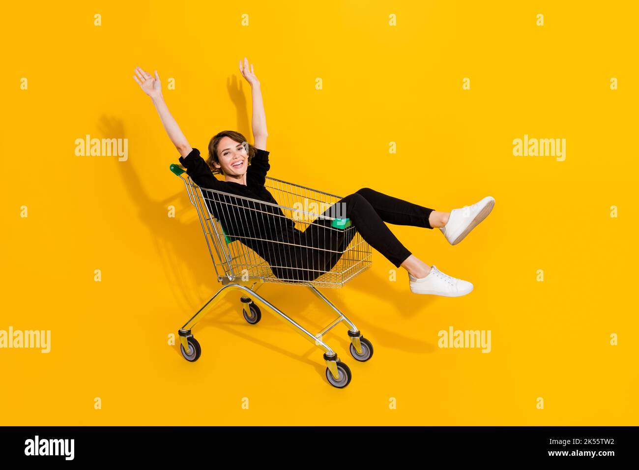 Photo of impressed funny lady wear black shirt rising arms riding ...