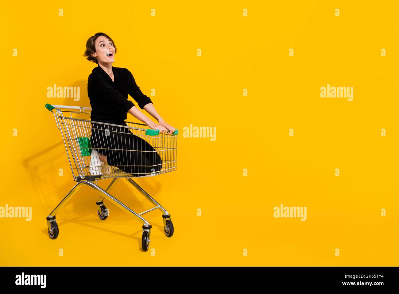 Photo of funny impressed lady wear black shirt riding shopping tray ...