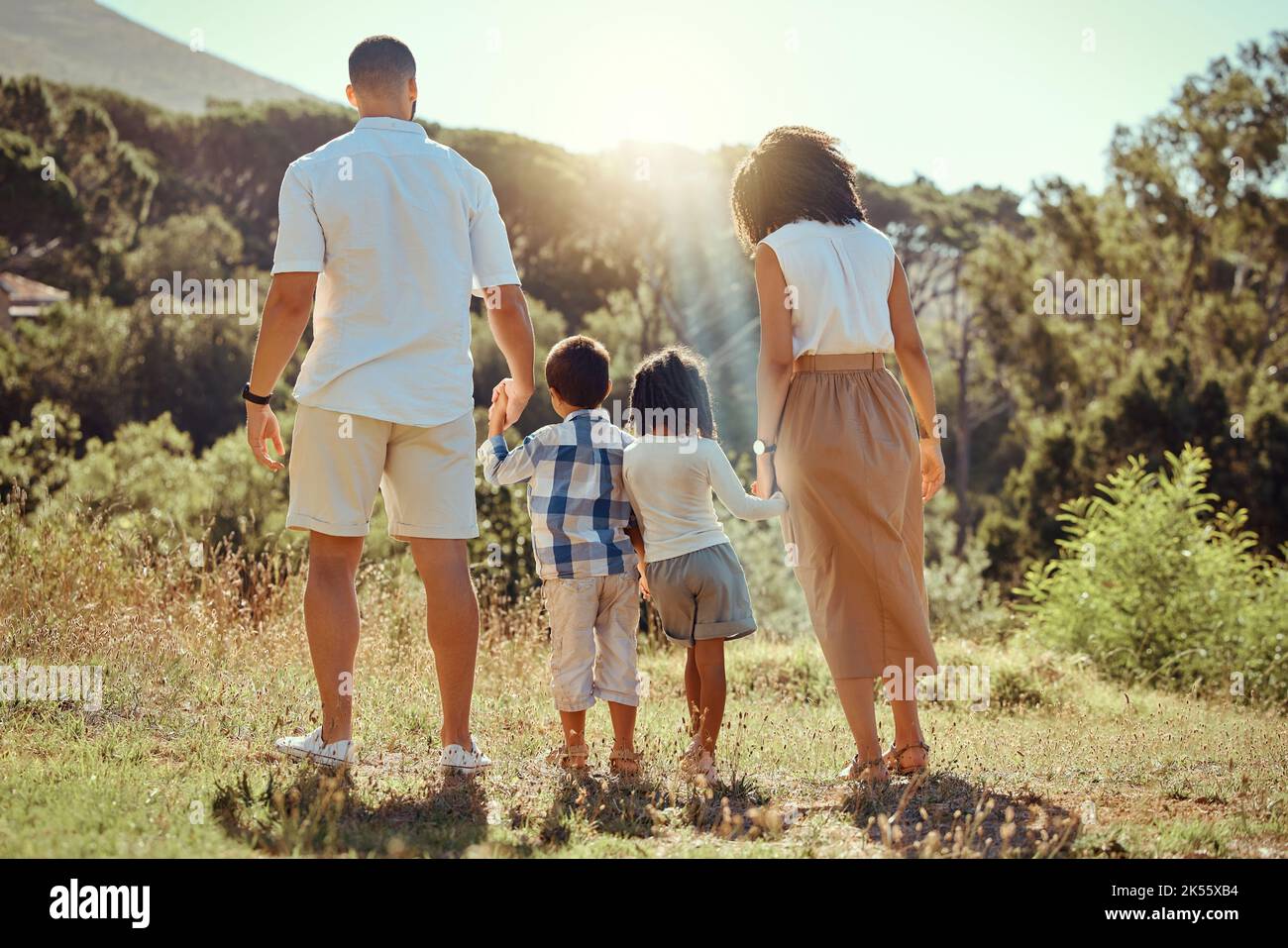 Family, walk and nature together with trees, grass and sunshine while ...