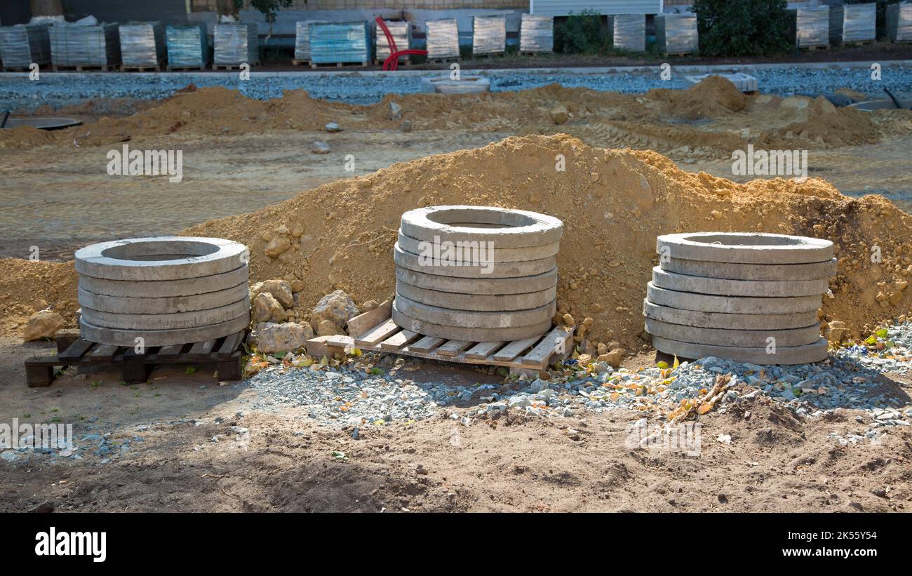 Reinforced concrete rings lie pallets at the construction site Stock ...