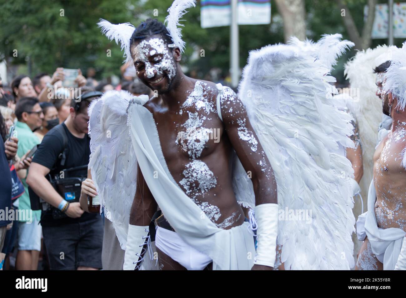A black person dressed like an angel with a white paint on the skin ...