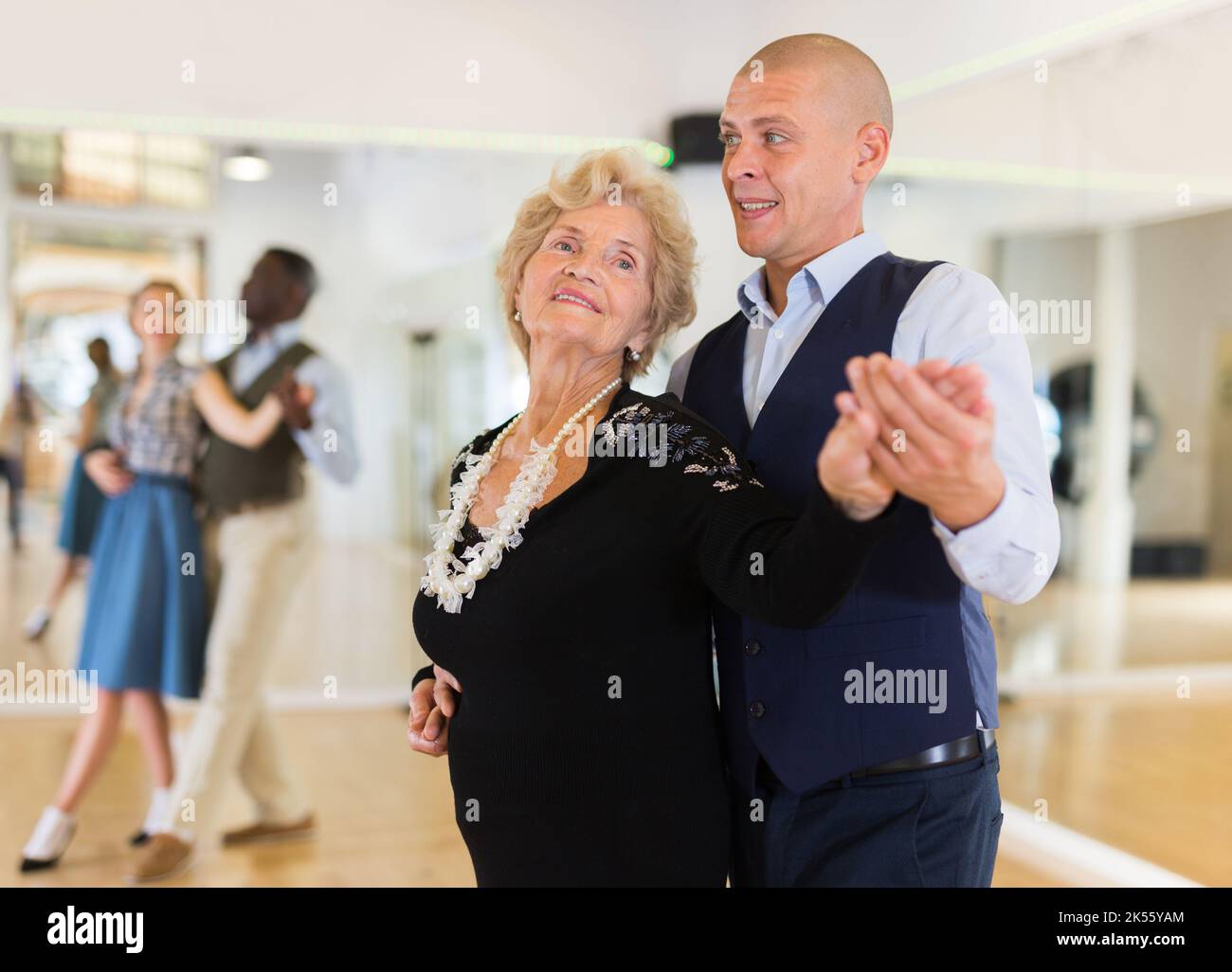 Elderly woman learning ballroom dancing movements in pair Stock Photo ...