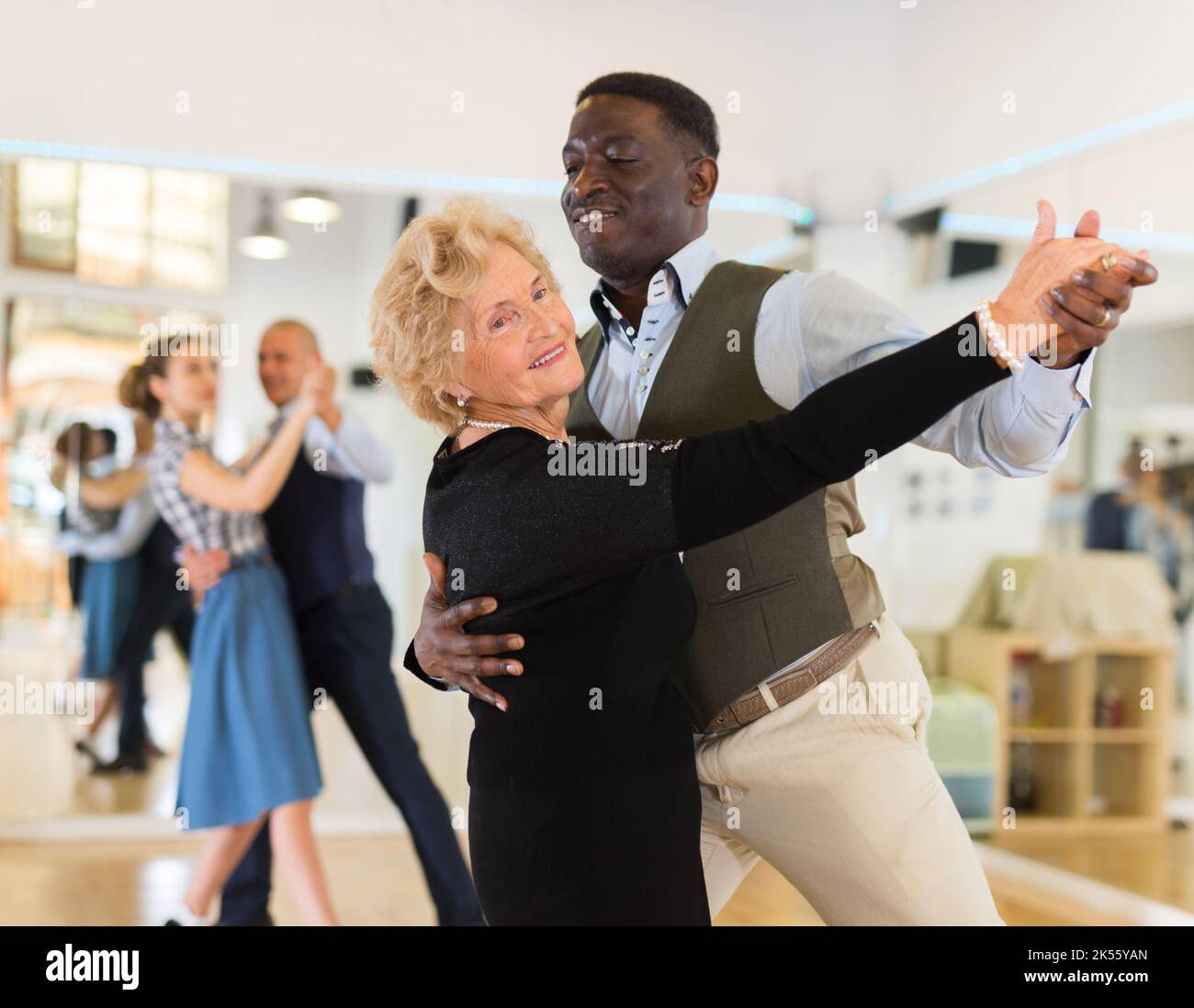 Elderly woman learning ballroom dancing in pair in dance studio Stock ...