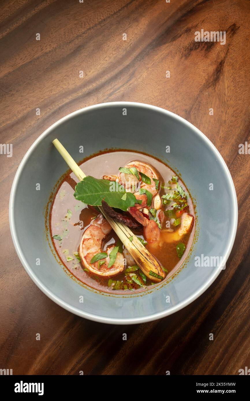 thai tom yam kung spicy curry soup with prawns on wood table Stock ...