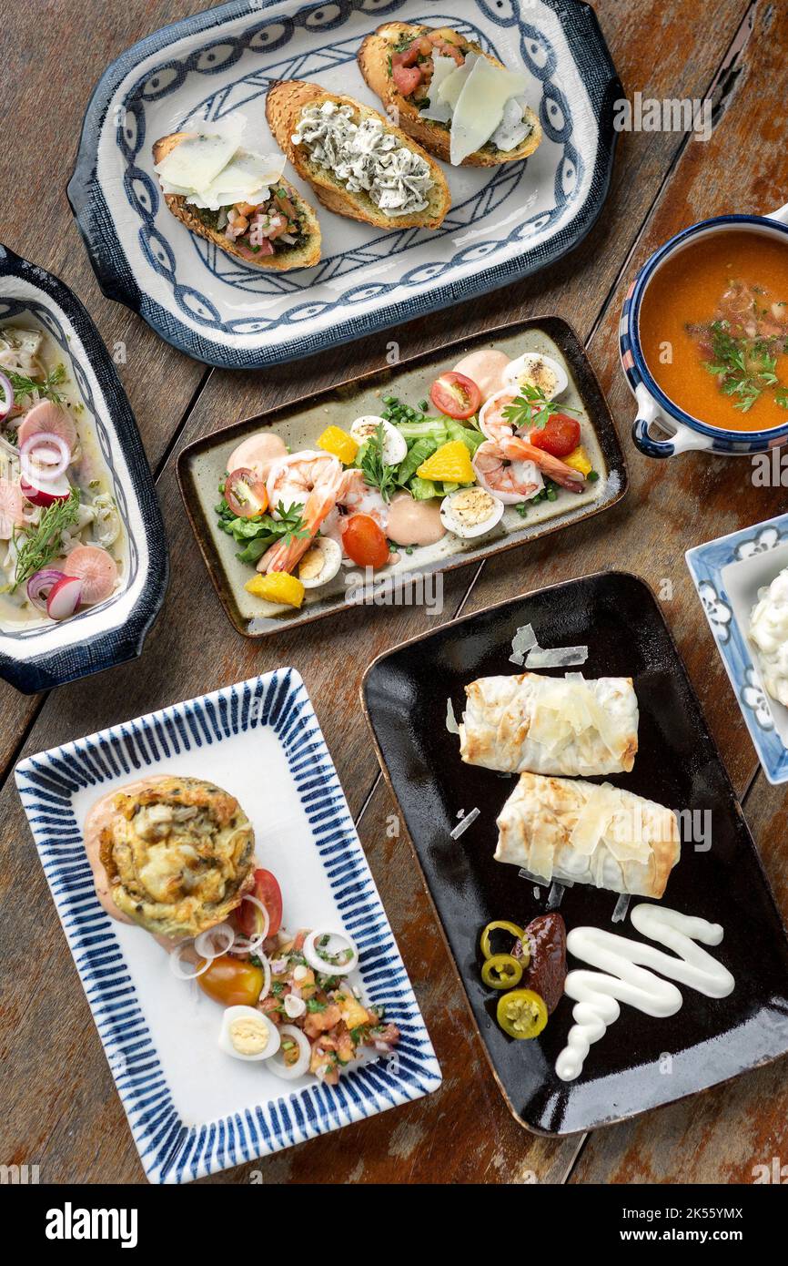 selection of many different mixed tapas on rustic wood table in ...