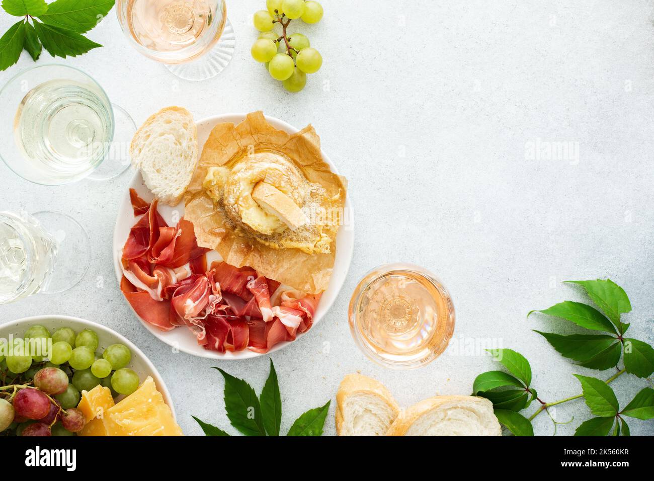 Top view of table with rose and white wine in glasses, plates with ...