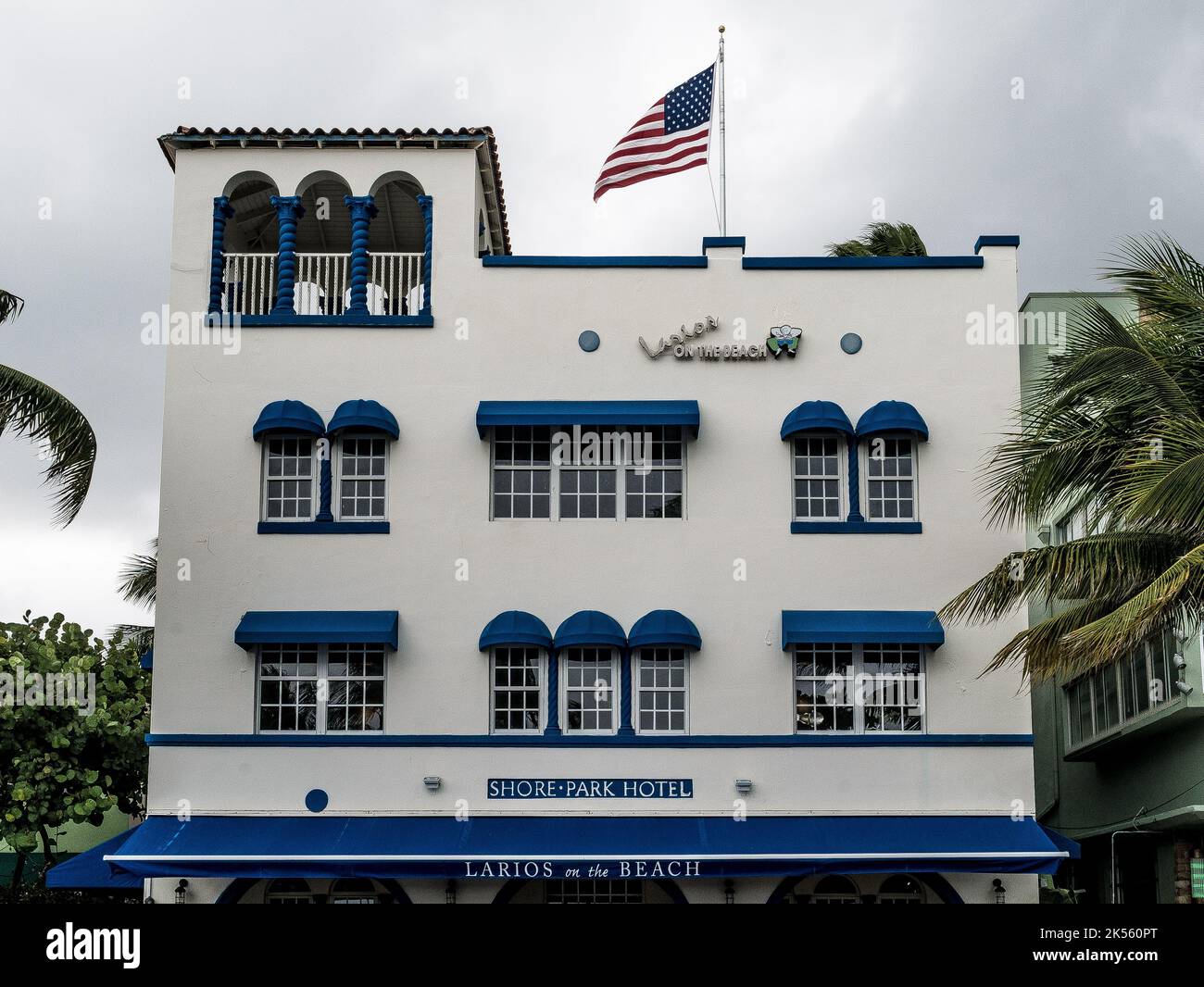 An Art Deco Building white with blue highlights and the American flag ...