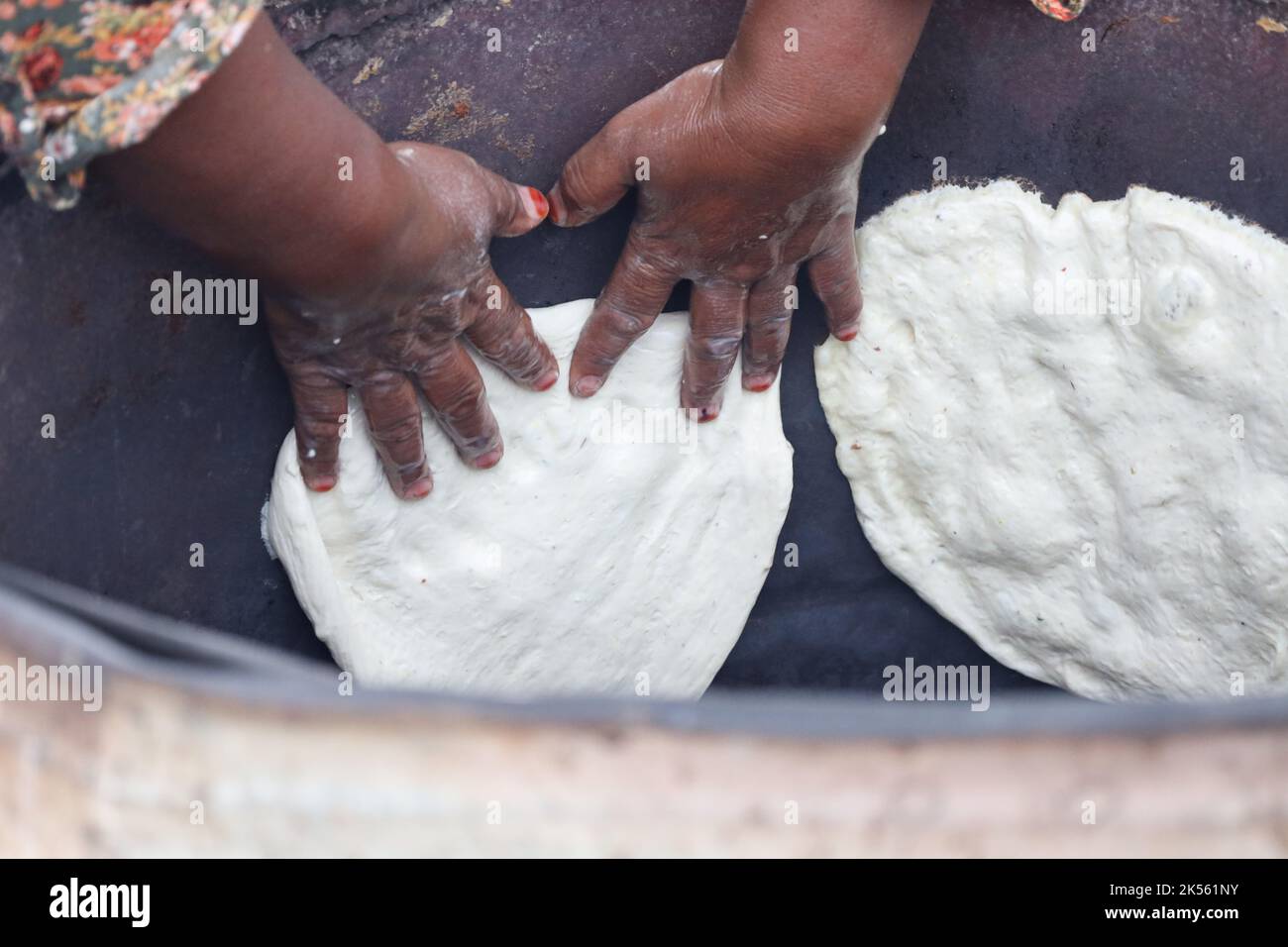 Misrata, Libya - 5 Oct 2022, A woman makes bread in a wood-fired oven ...