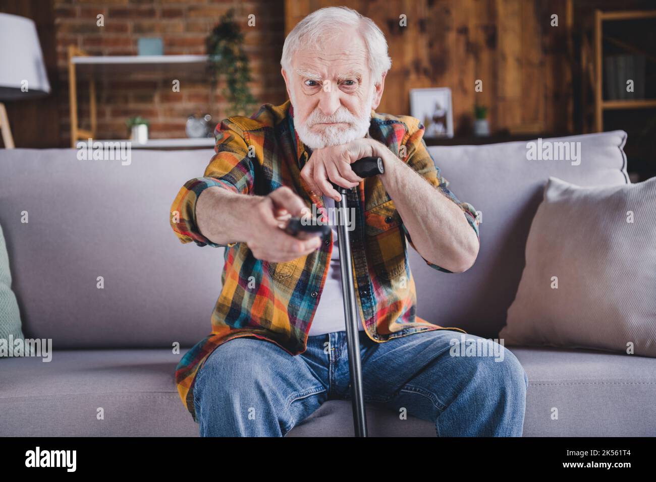 Photo of angry irritated man pensioner wear checkered shirt changing tv ...
