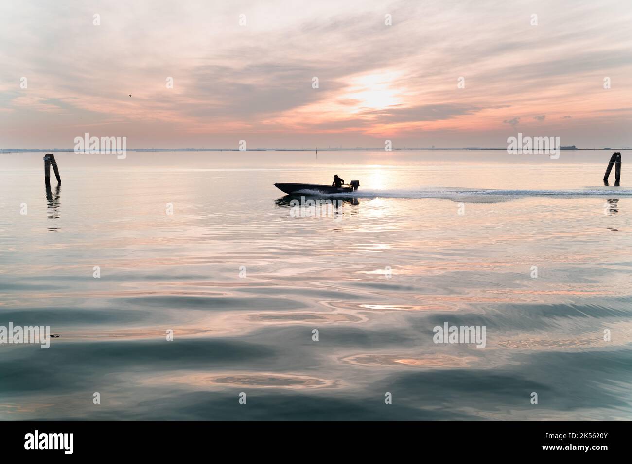 early morning fisher riding his boat to catch some fish Stock Photo - Alamy