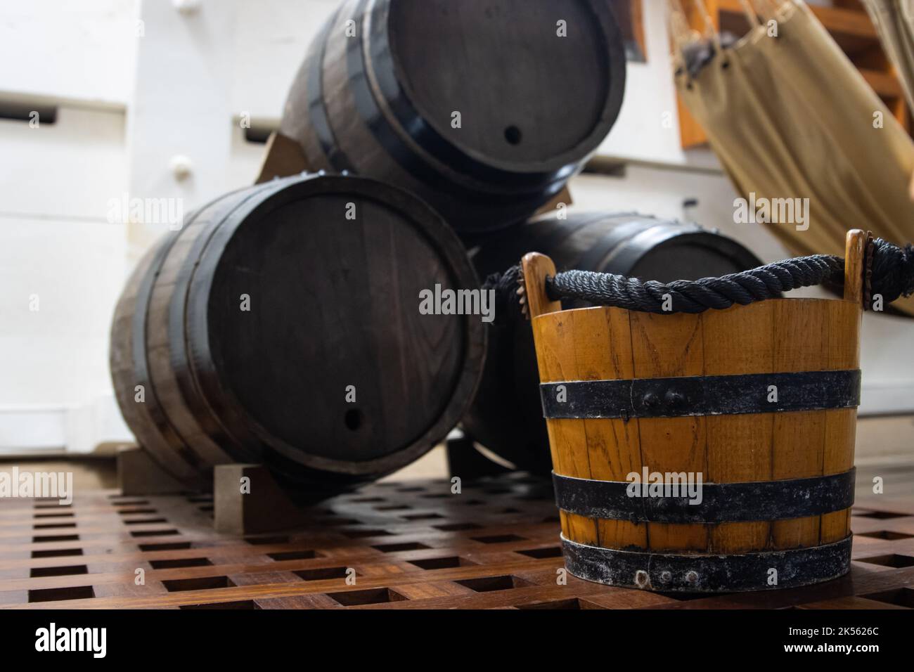 Wooden bucket near powder barrels in storage room on the battle vessel ...