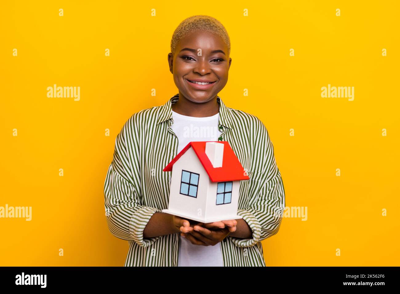 Photo of positive cheerful girl arms hold little house toothy smile ...