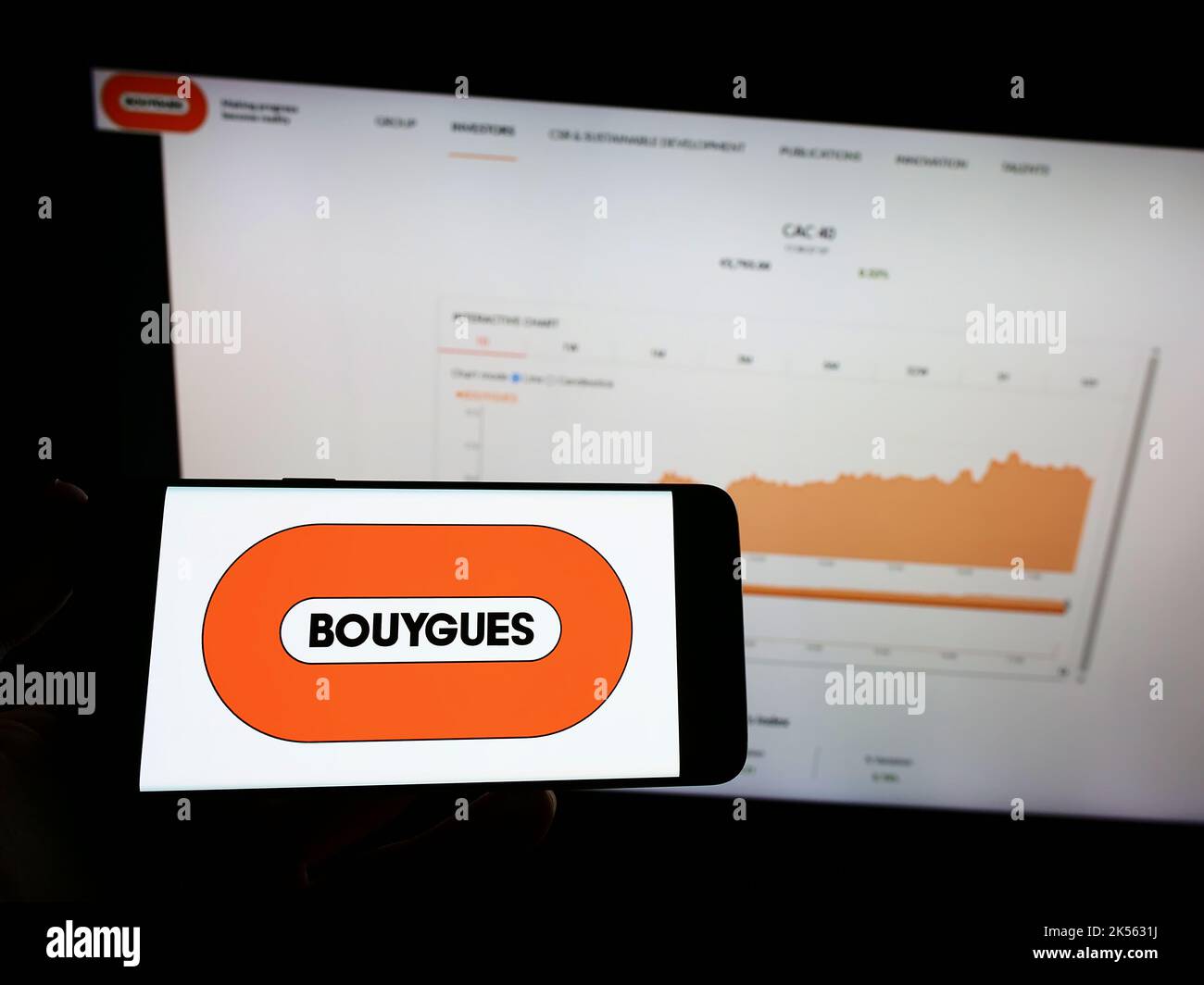 Person holding mobile phone with logo of French conglomerate Bouygues S ...