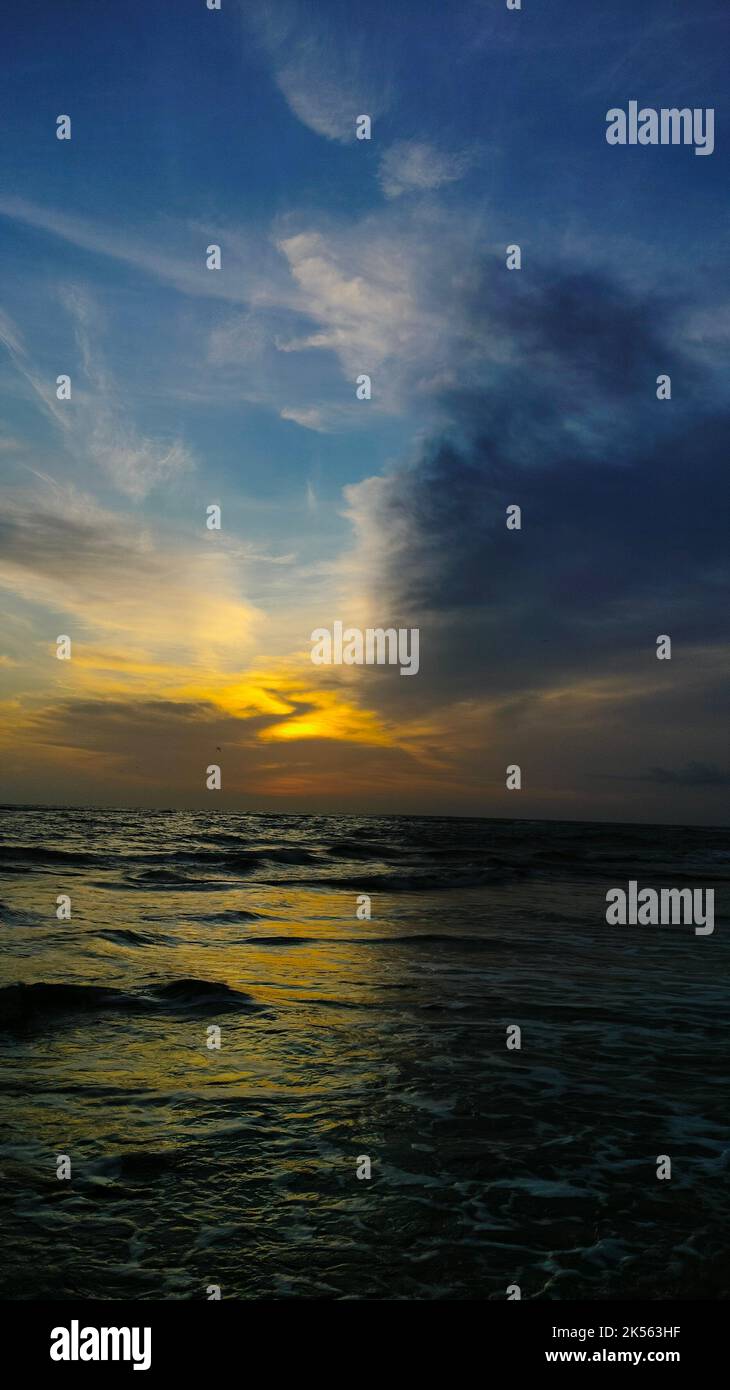 A vertical shot of the beautiful sunset at Kerala public property beach ...
