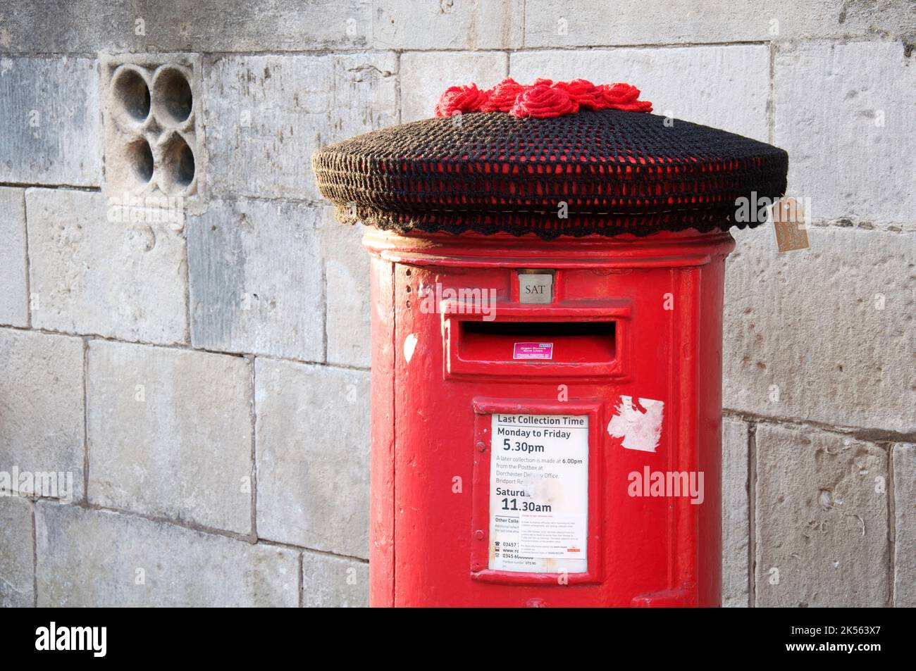 A black knitted woollen hat covers a red pillar box. Commemorating the ...