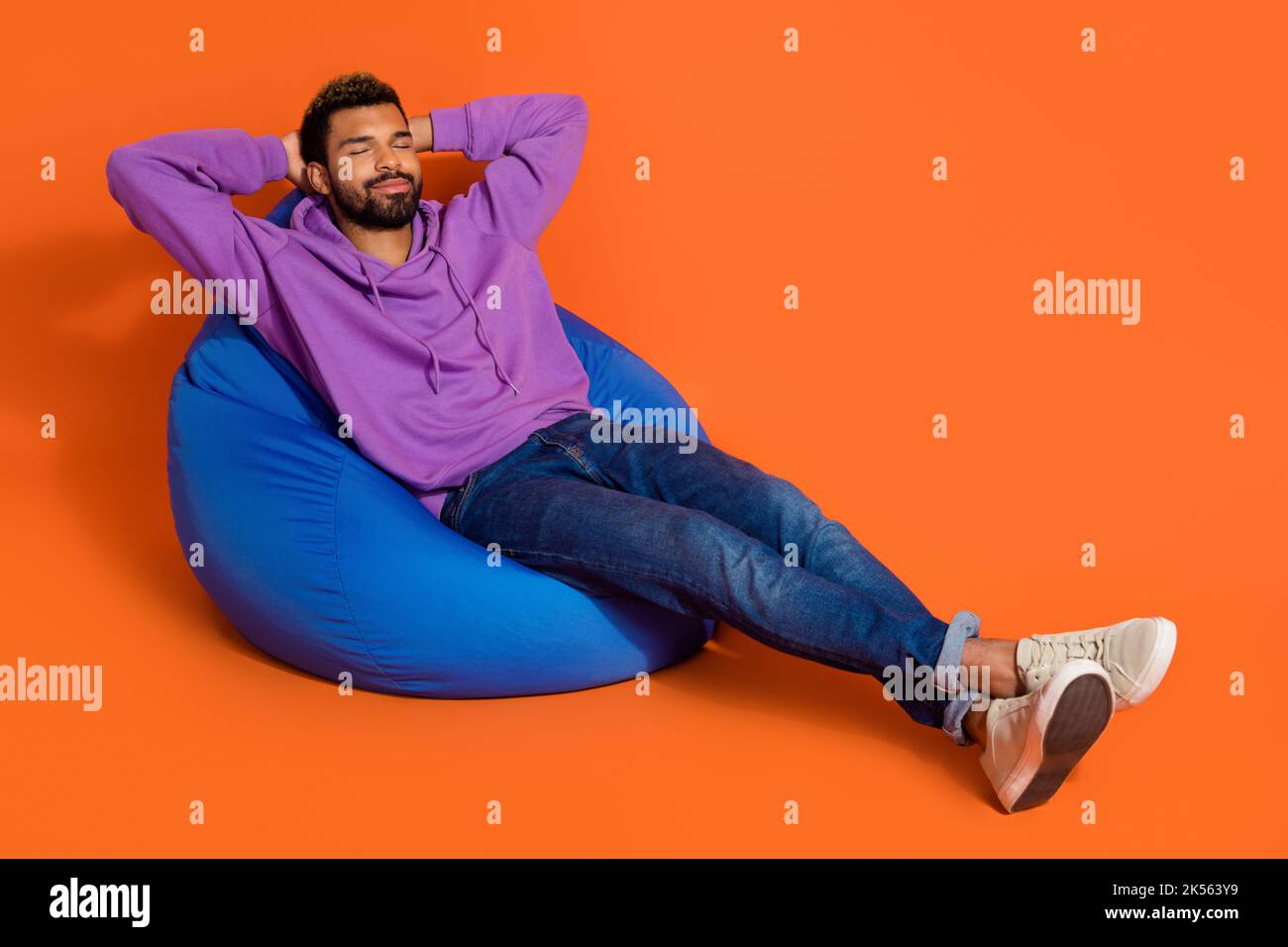 Full length portrait of positive nice person sit comfy bag hands behind ...