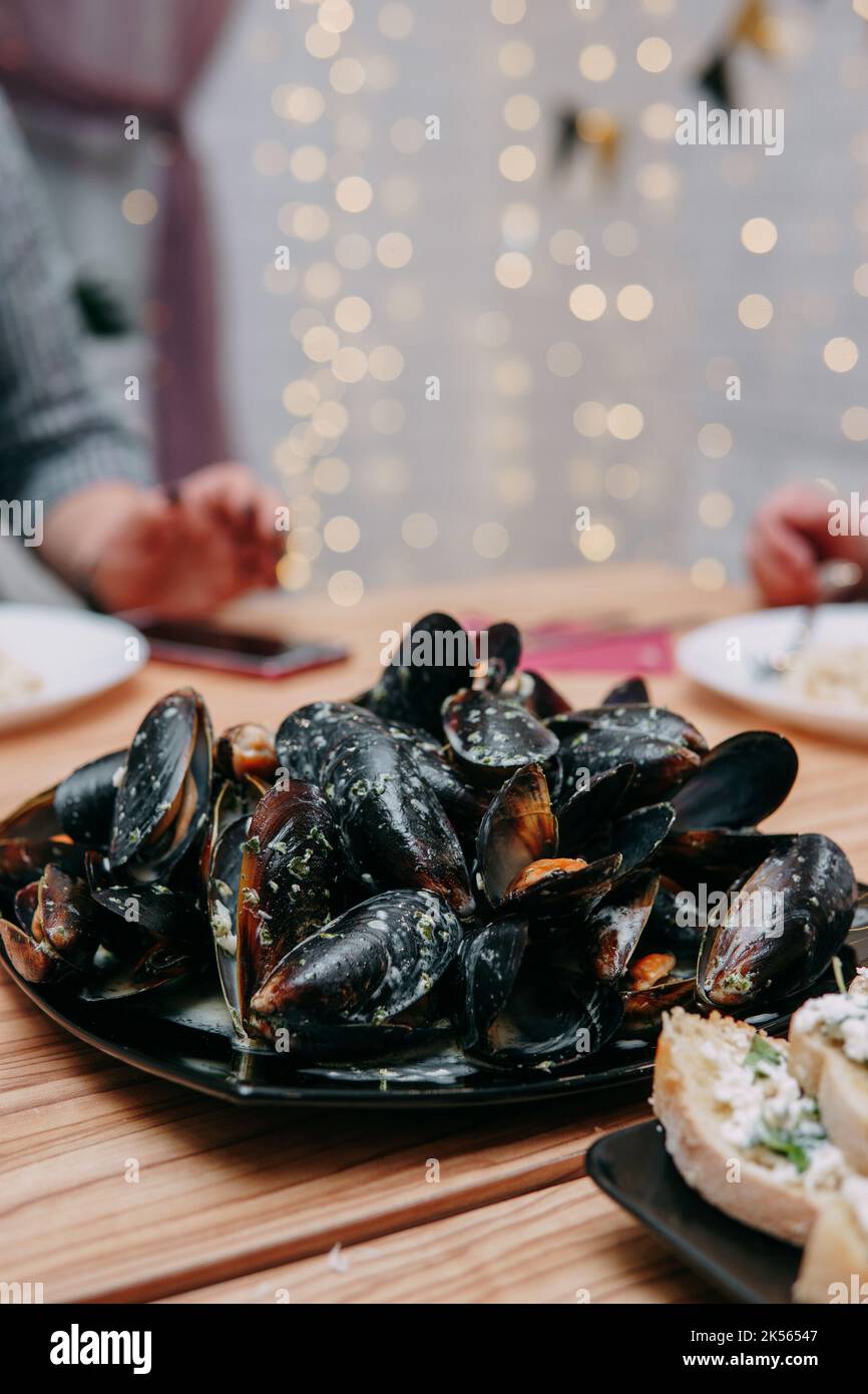 Raw mussels on a black plate at a cooking class. Master class on ...