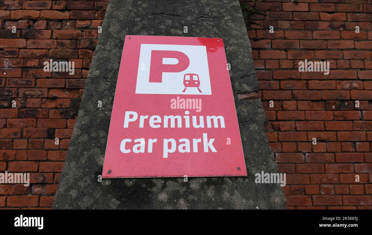 A red and white parking sign on a wall saying Premium car park Stock ...