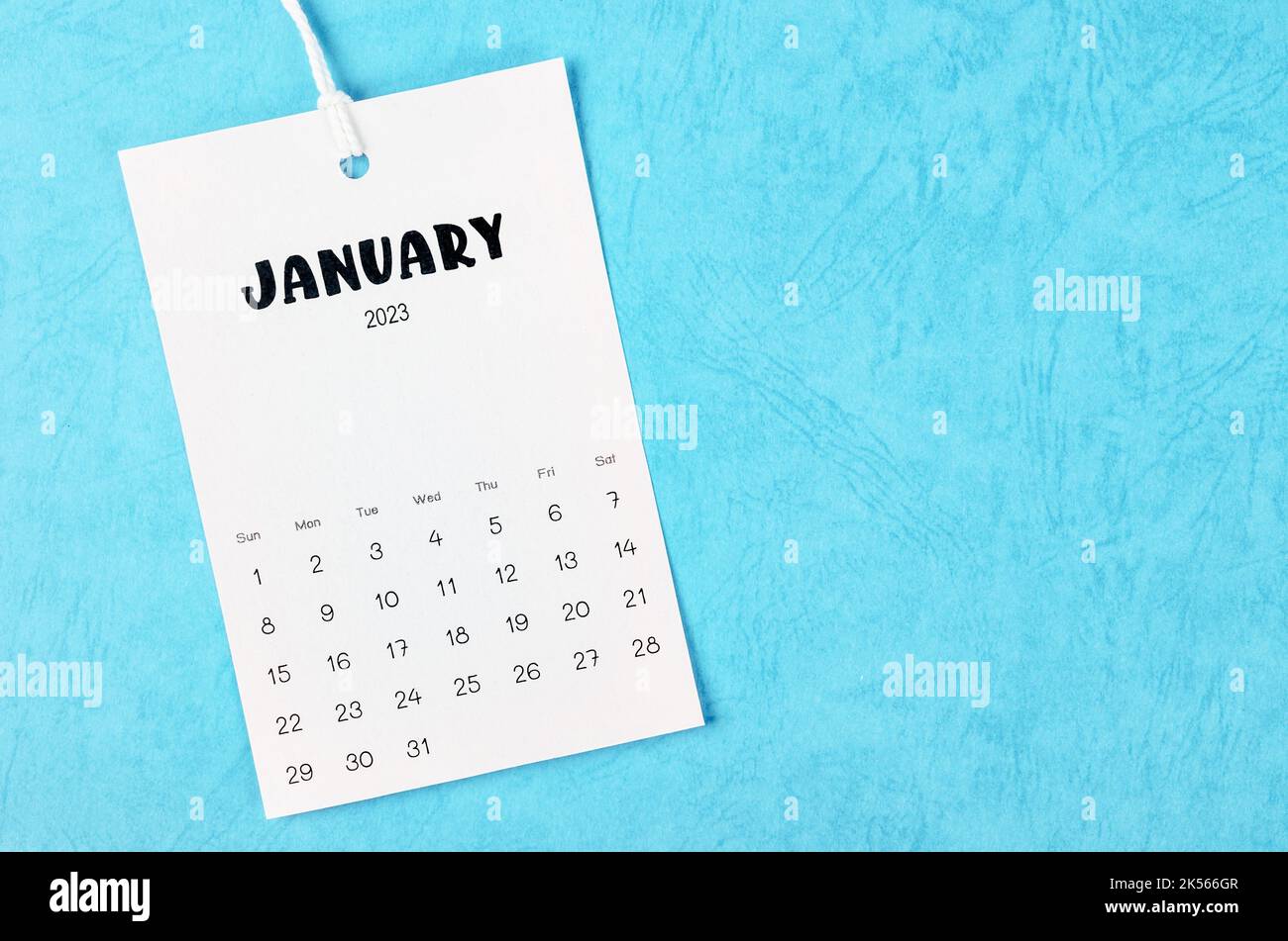 2023 January calendar page hanged on white rope on blue background ...
