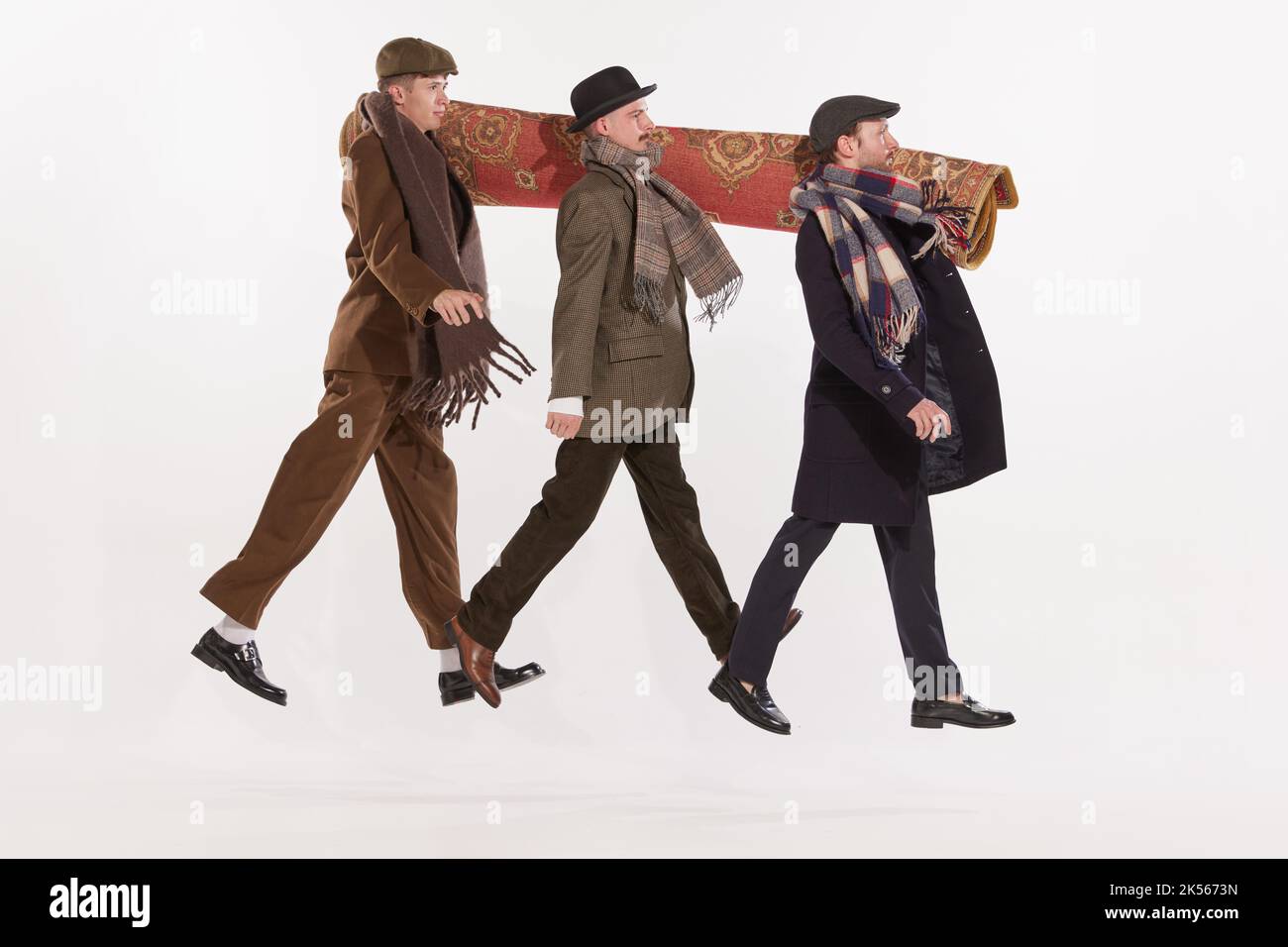 Portrait of three men in autumn clothes walking together and carrying ...